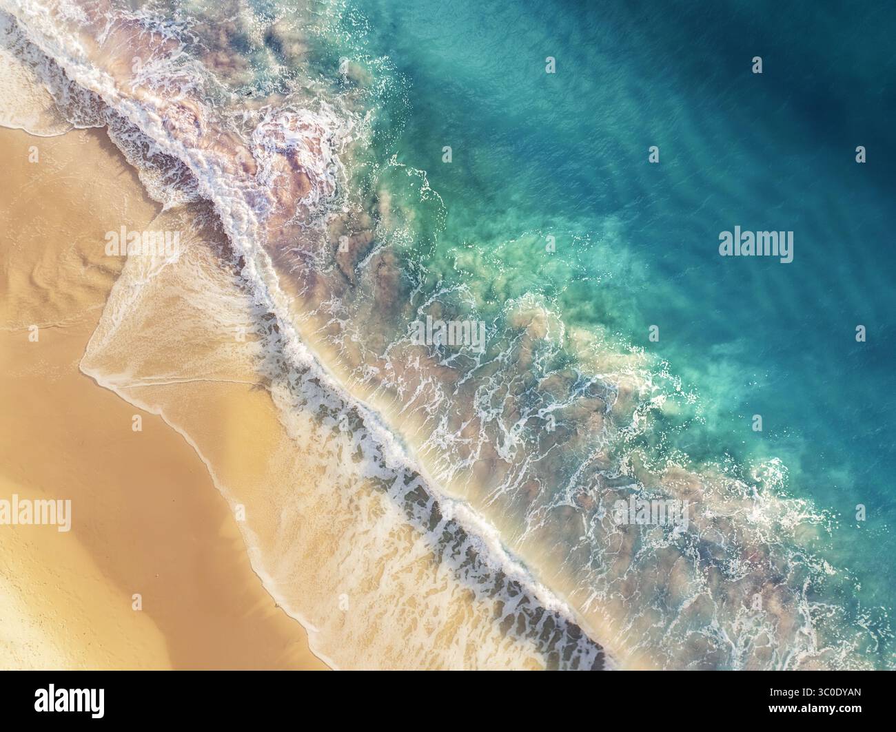 Aerial view of the shoreline's stark contrast where golden sands meet ...