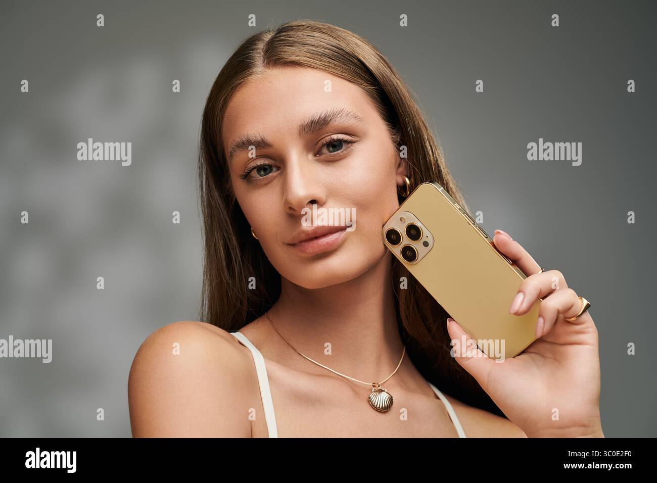A young woman with tan skin and natural makeup poses confidently with ...