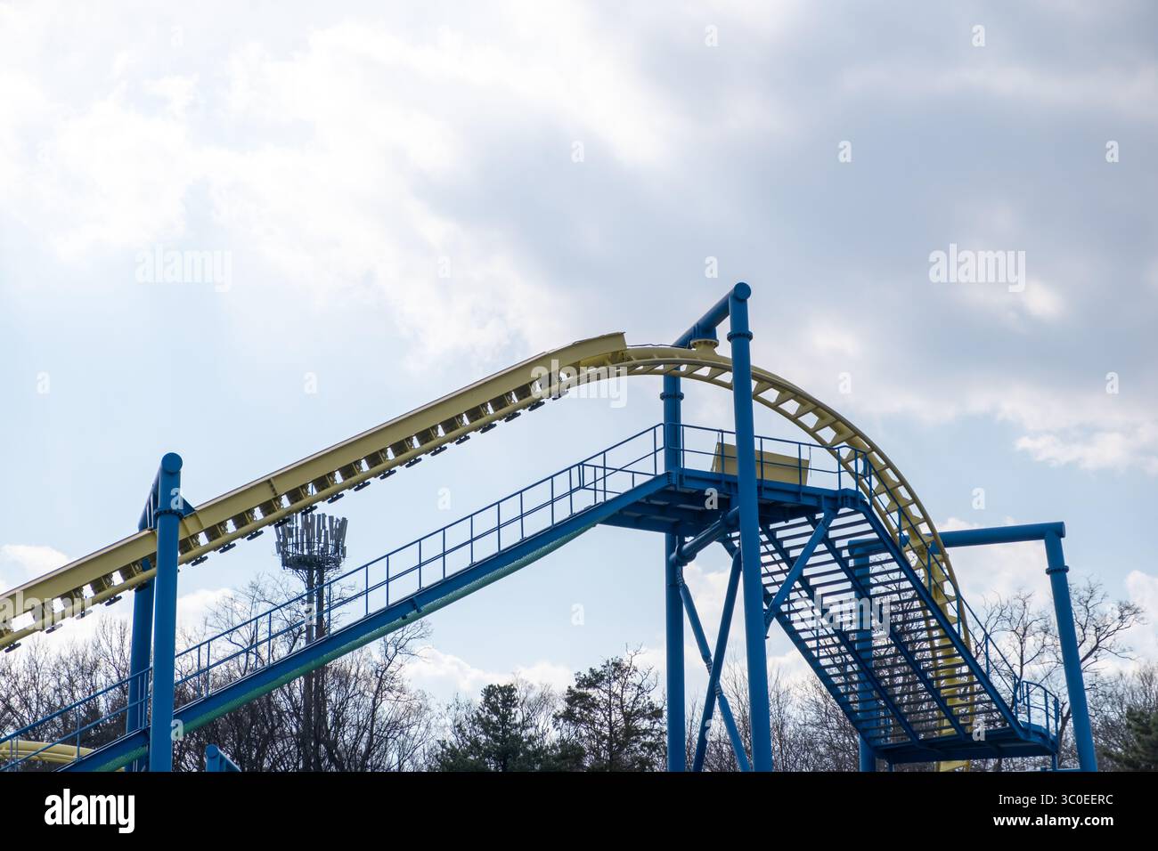 Yellow and blue track for the ride in amusement park against blue sky ...