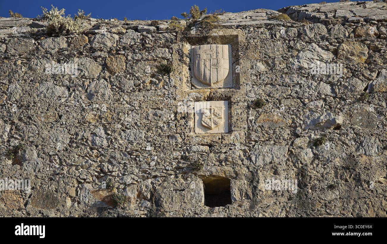 Medieval stone wall with engraved coats of arms and weathered ...