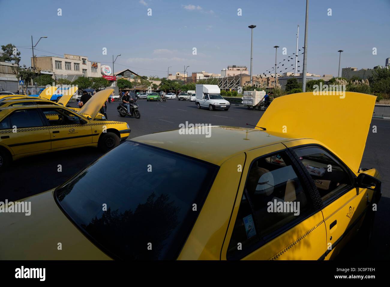 Taxi drivers prop the hoods of their cars open while waiting for ...