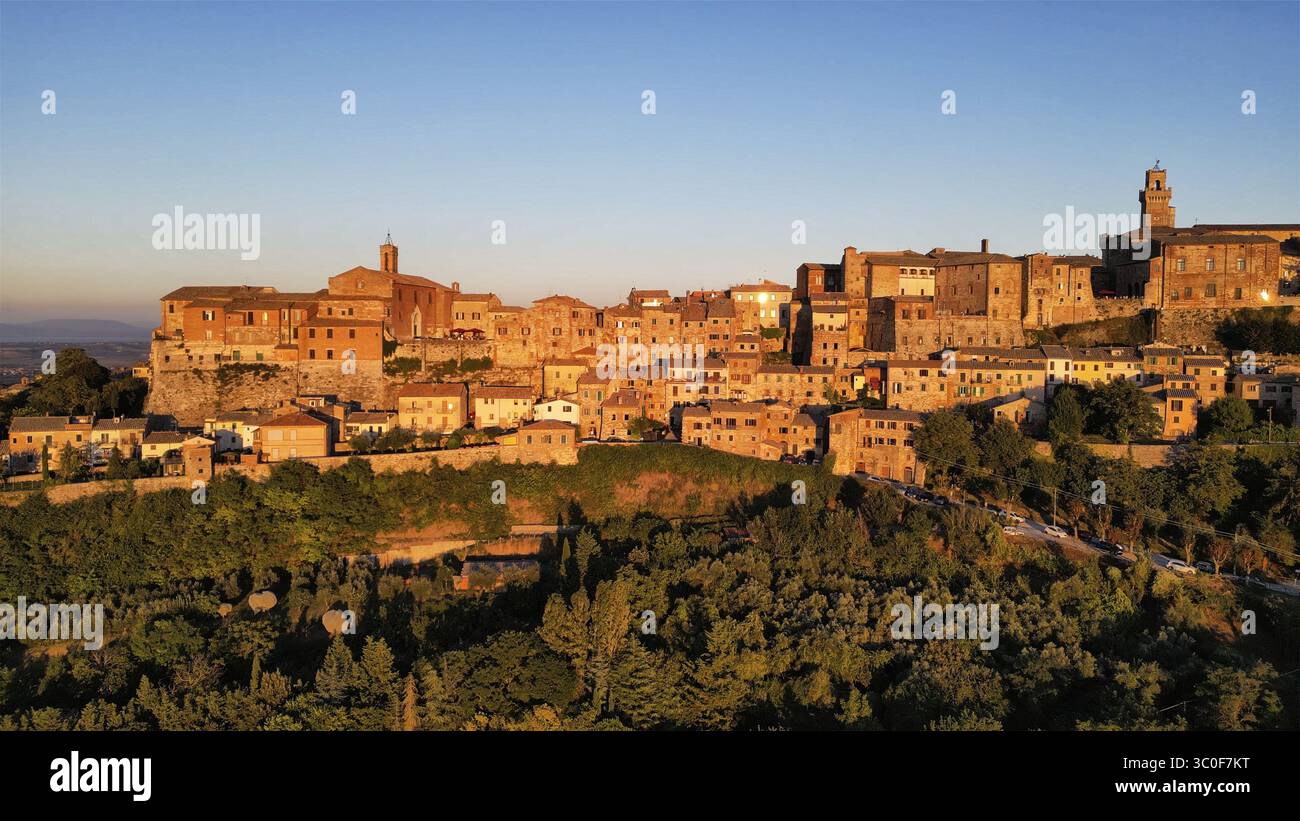 Aerial view of a sun-kissed medieval townscape, with terracotta roofs ...