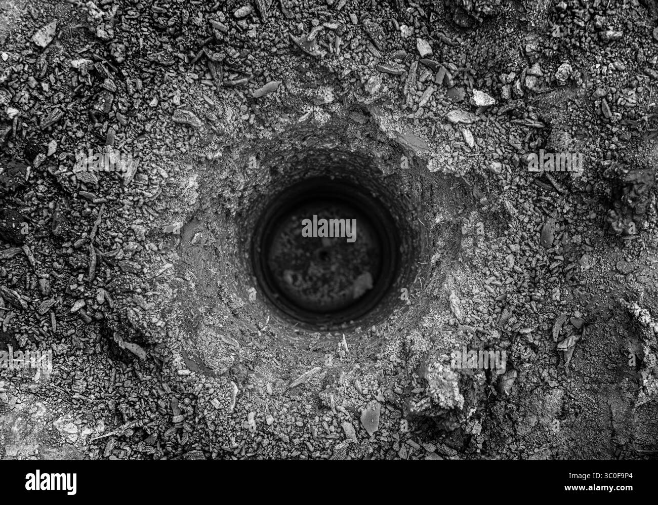 Freshly drilled hole in the rough soil, showing detailed texture of ...