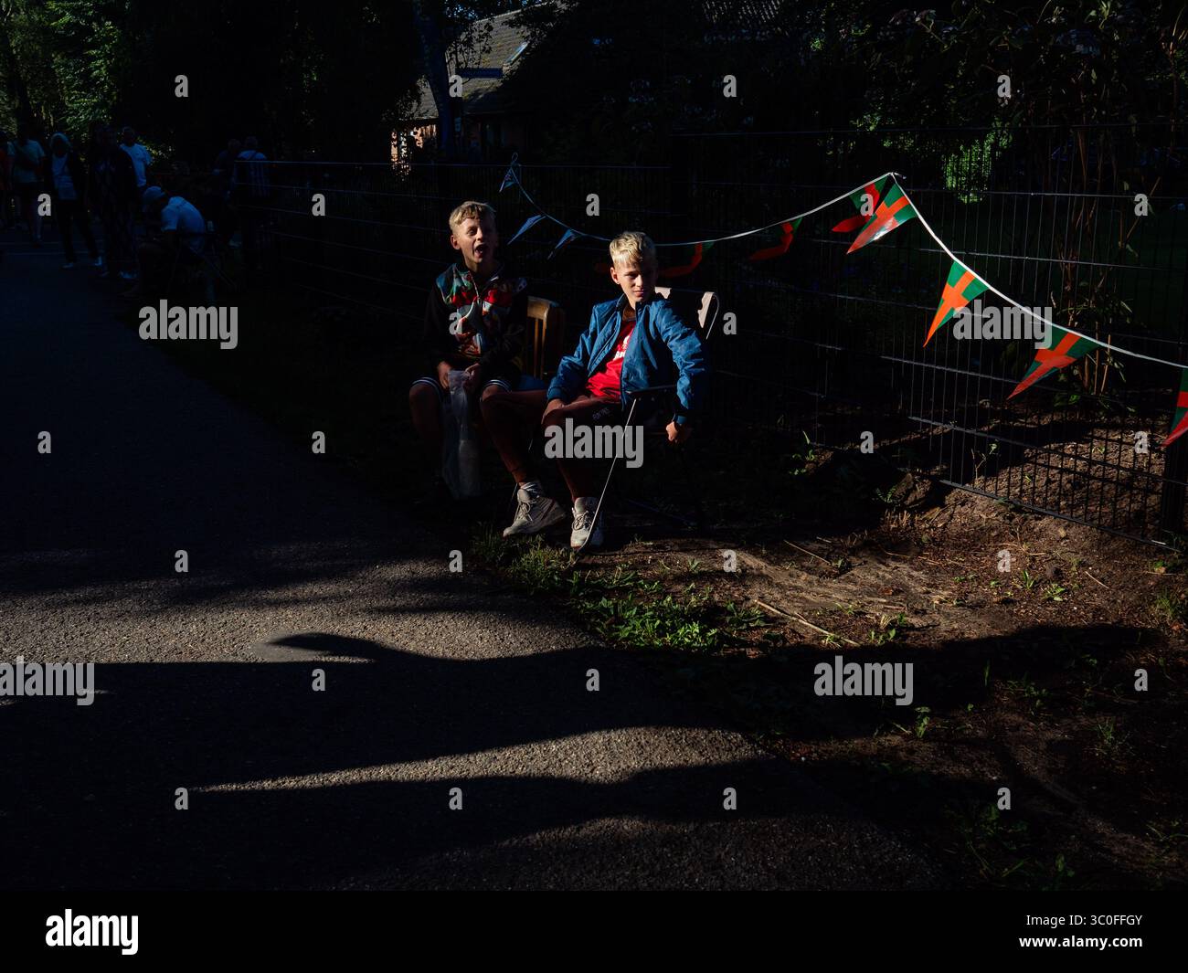 Two children are seen cheering the walkers passing by. The ...