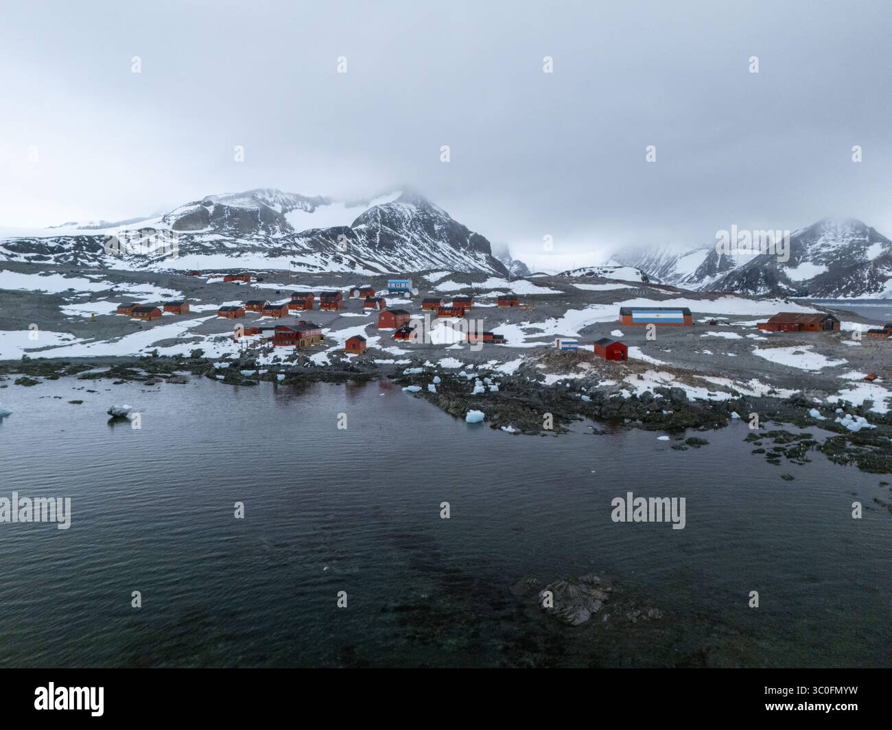 Aerial view of red-roofed buildings nestled against a snowy ...