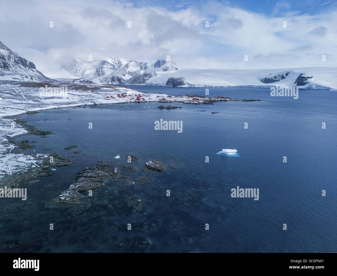 Aerial view of the rugged, snow-dusted landscape meeting the frigid ...