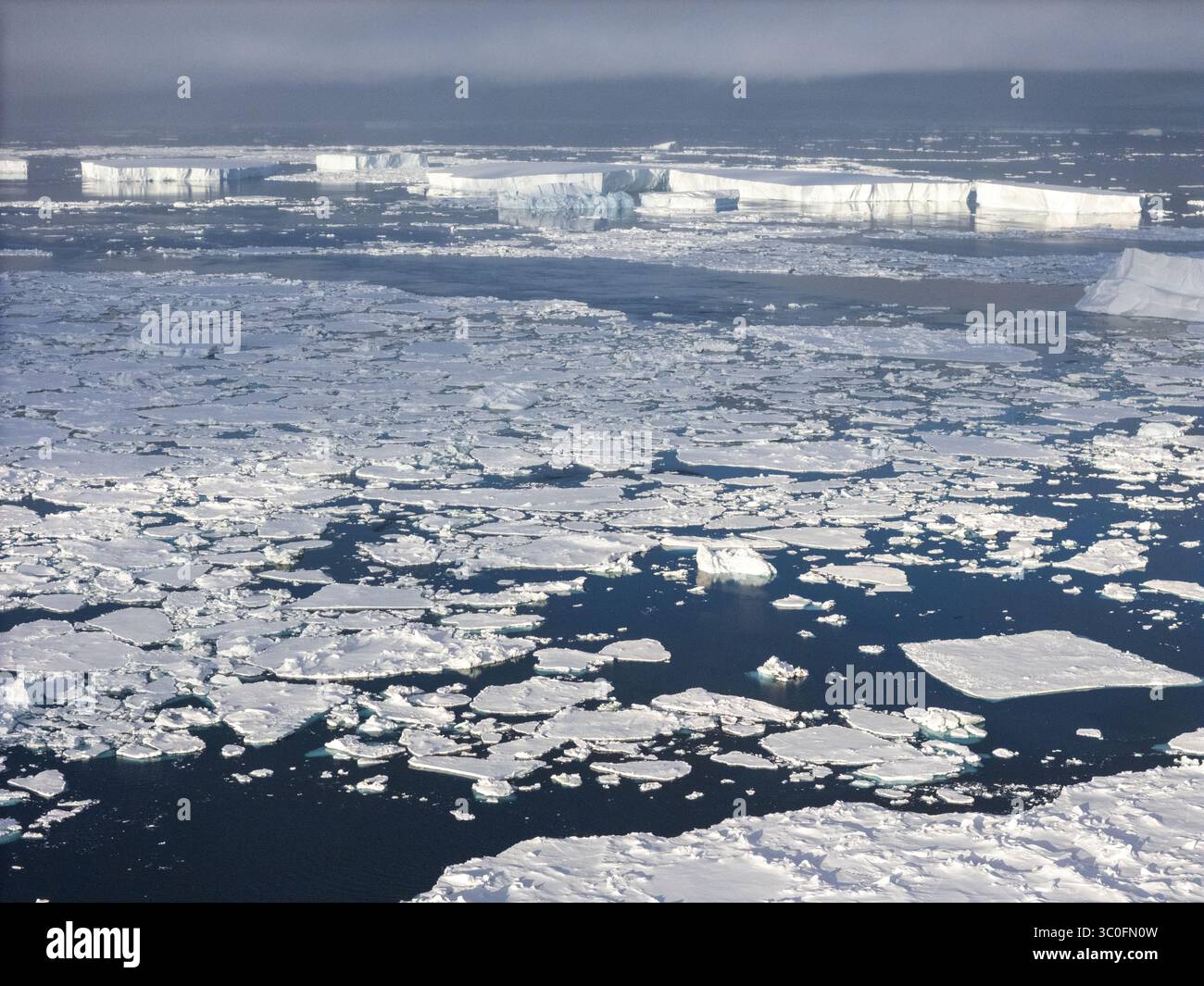 Aerial view of the stark, contrasting white ice floes against the deep ...