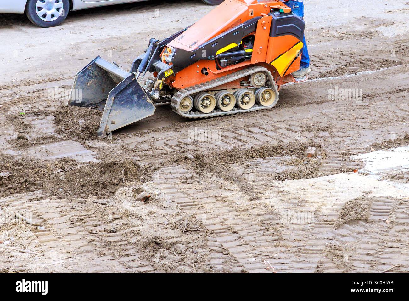 Small construction vehicle is leveling dirt at worksite for ...