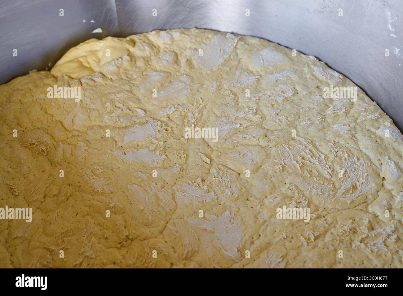 Dough resting in troughs at a bustling bread factory during morning ...