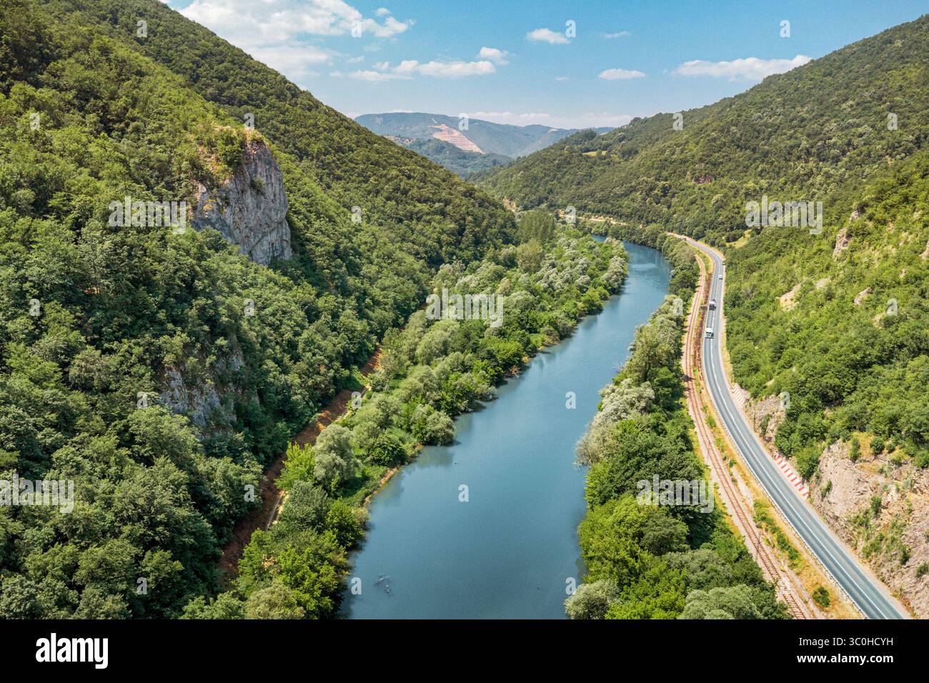 Cars and trucks driving on a highway and railway following the Western ...