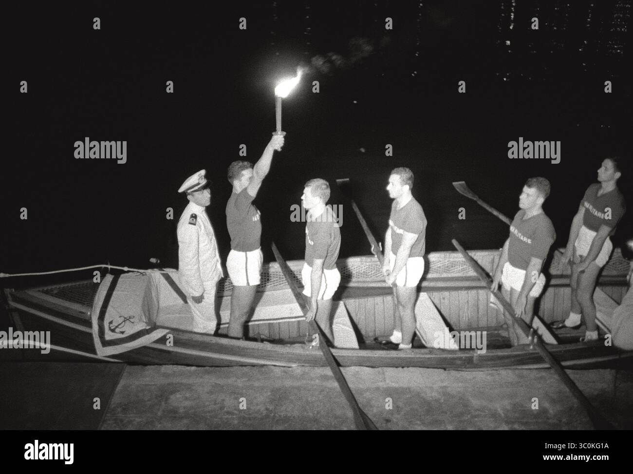 The Olympic torch is carried aboard a boat to reach the training ship ...