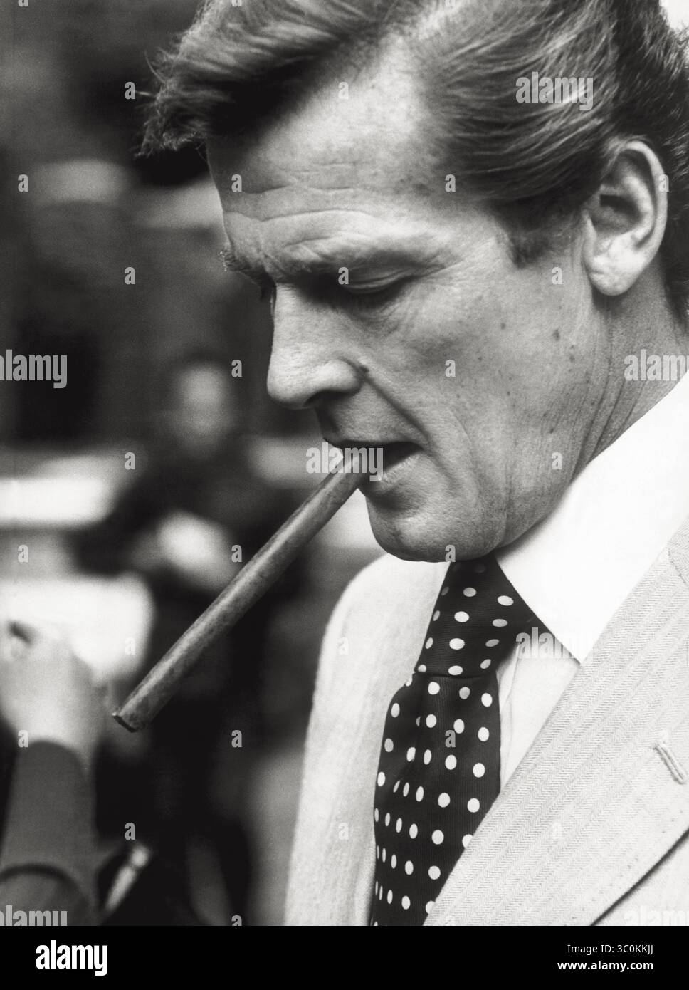 A close-up of the British actor Roger Moore smoking a cigar. Rome, 1974 ...