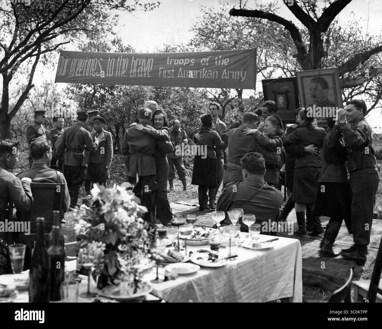 U.S. and Russian soldiers dancing with Russian auxiliaries in front of ...
