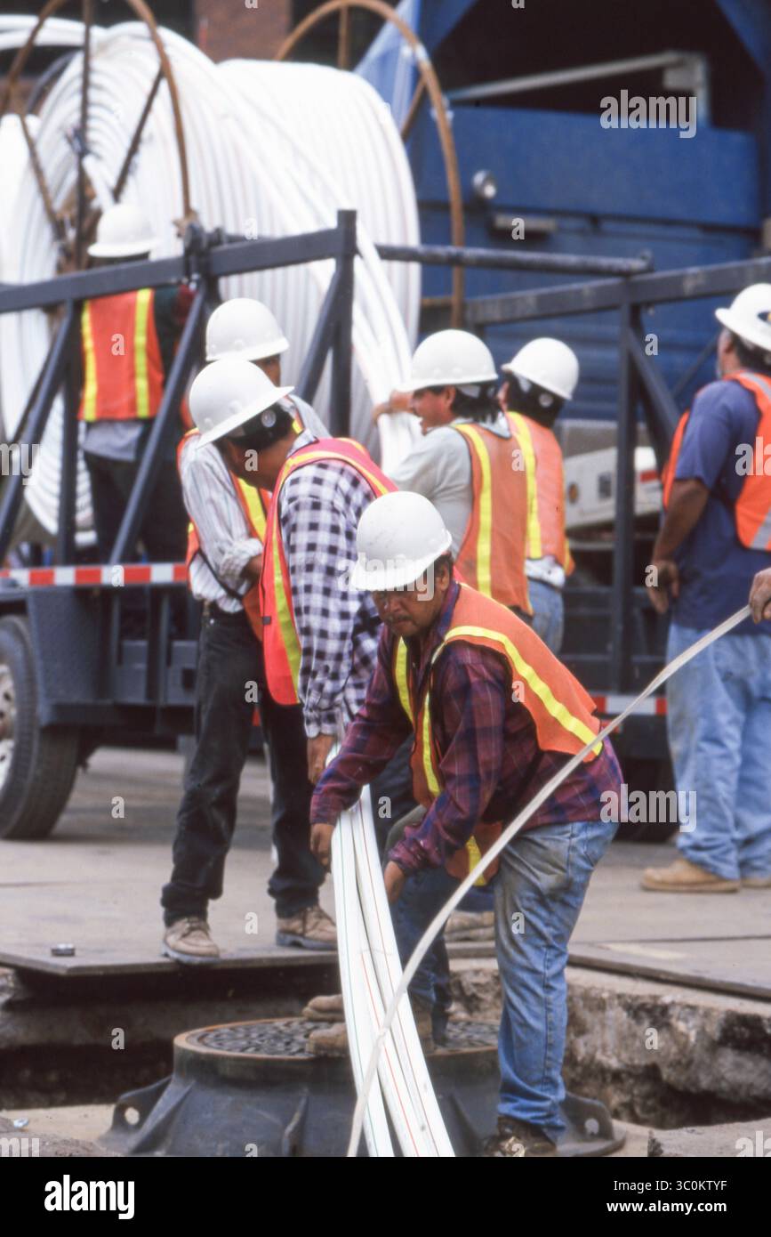Austin Texas USA, 2000: Workers lay fiber optic cable underneath the ...