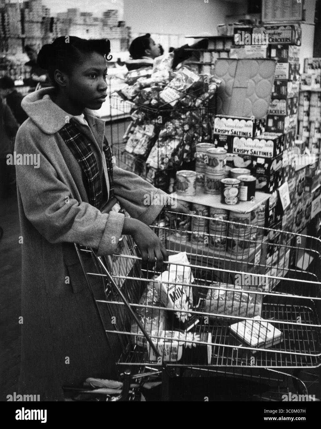 An African American girl pushing a shopping trolley in a Harlem ...