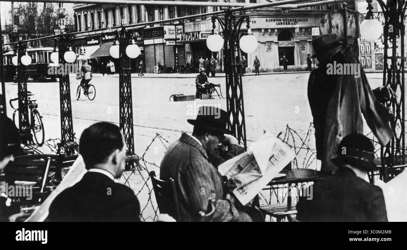 Austrian civilians sitting in an outdoor cafÃ© protected by barbed wire ...