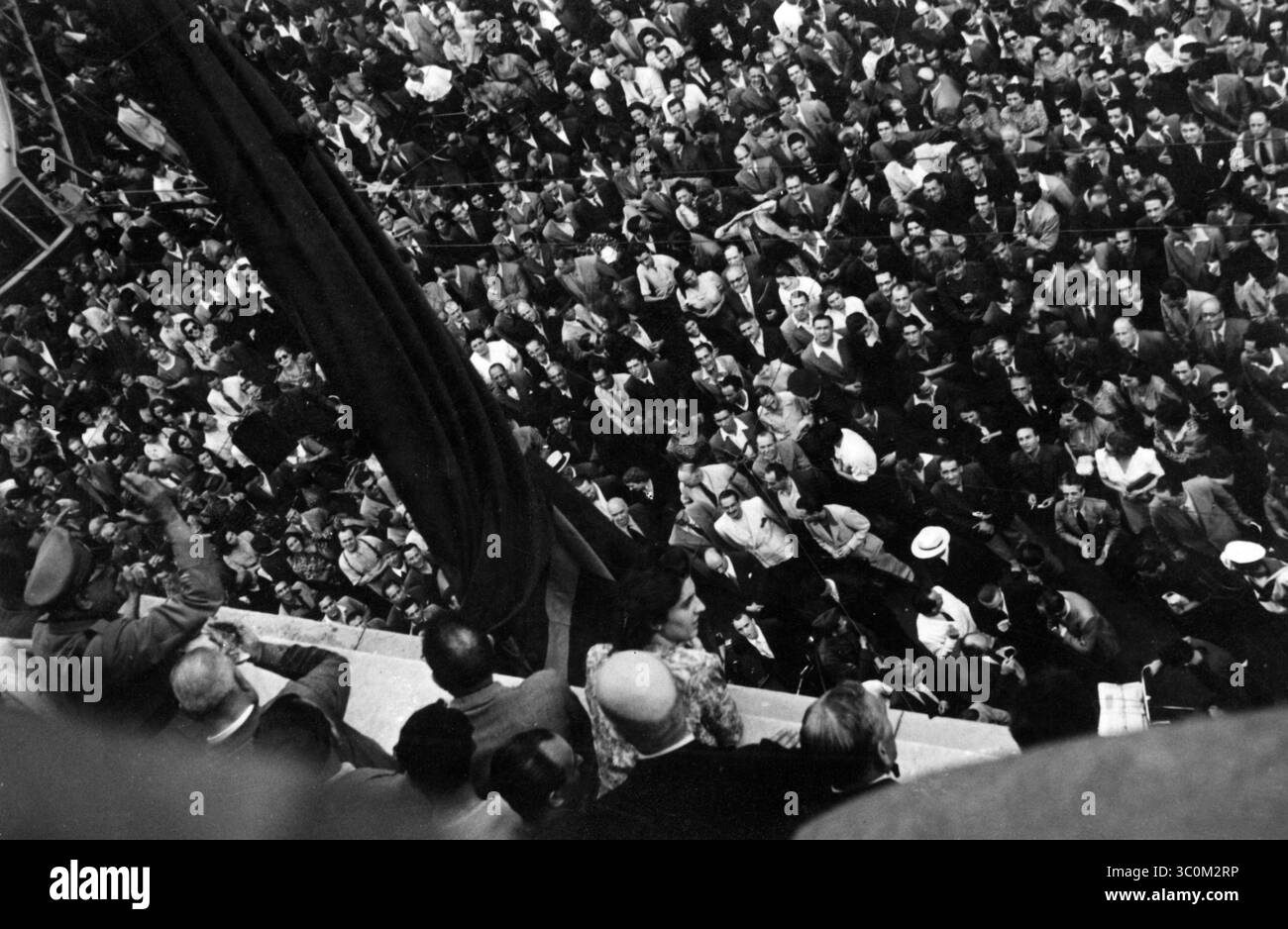 From the balcony of a building an officer is speaking to the crowd ...
