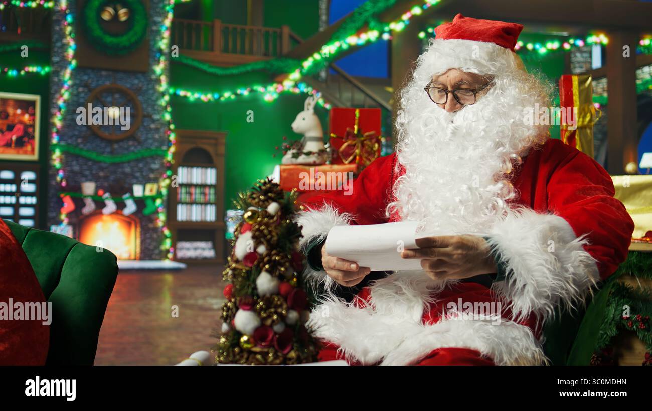 Smiling Santa Claus reading letters from kids, answering them, helping ...