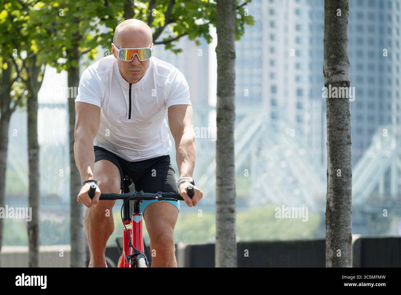 Handsome caucasian cyclist relax on bicycle at summer public park ...