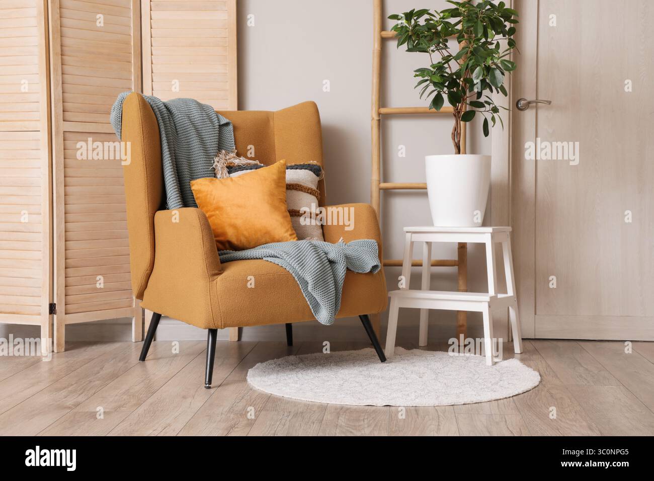 Stylish interior of living room with cozy armchair and wooden folding ...