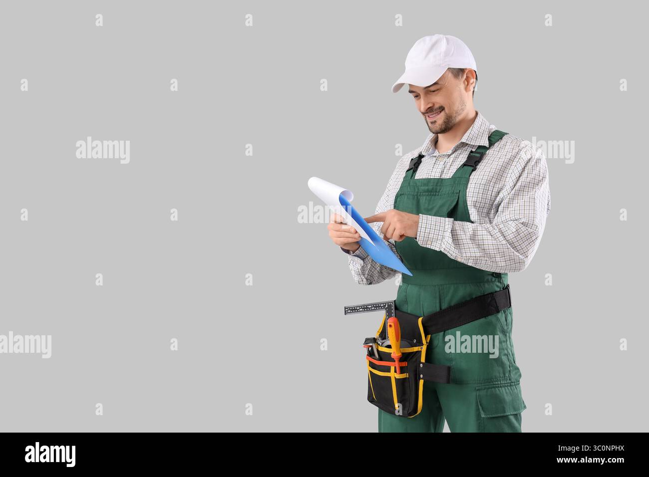 Male technician with clipboard on light background Stock Photo - Alamy