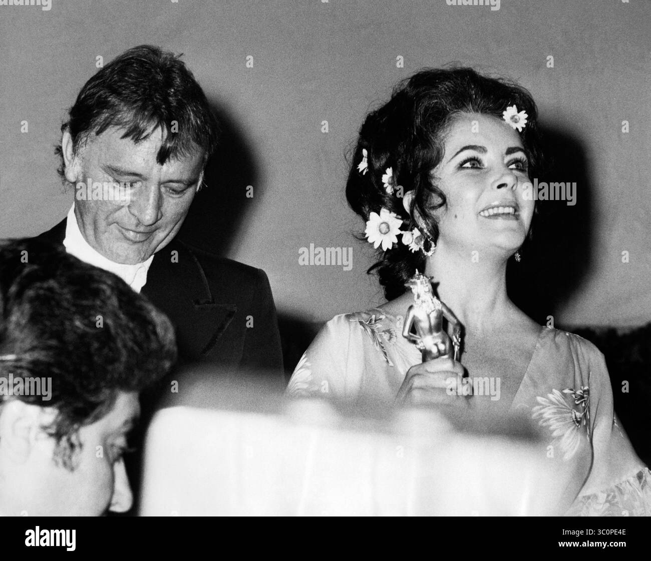A satisfied Elizabeth Taylor, in her husband Richard Burton's company ...