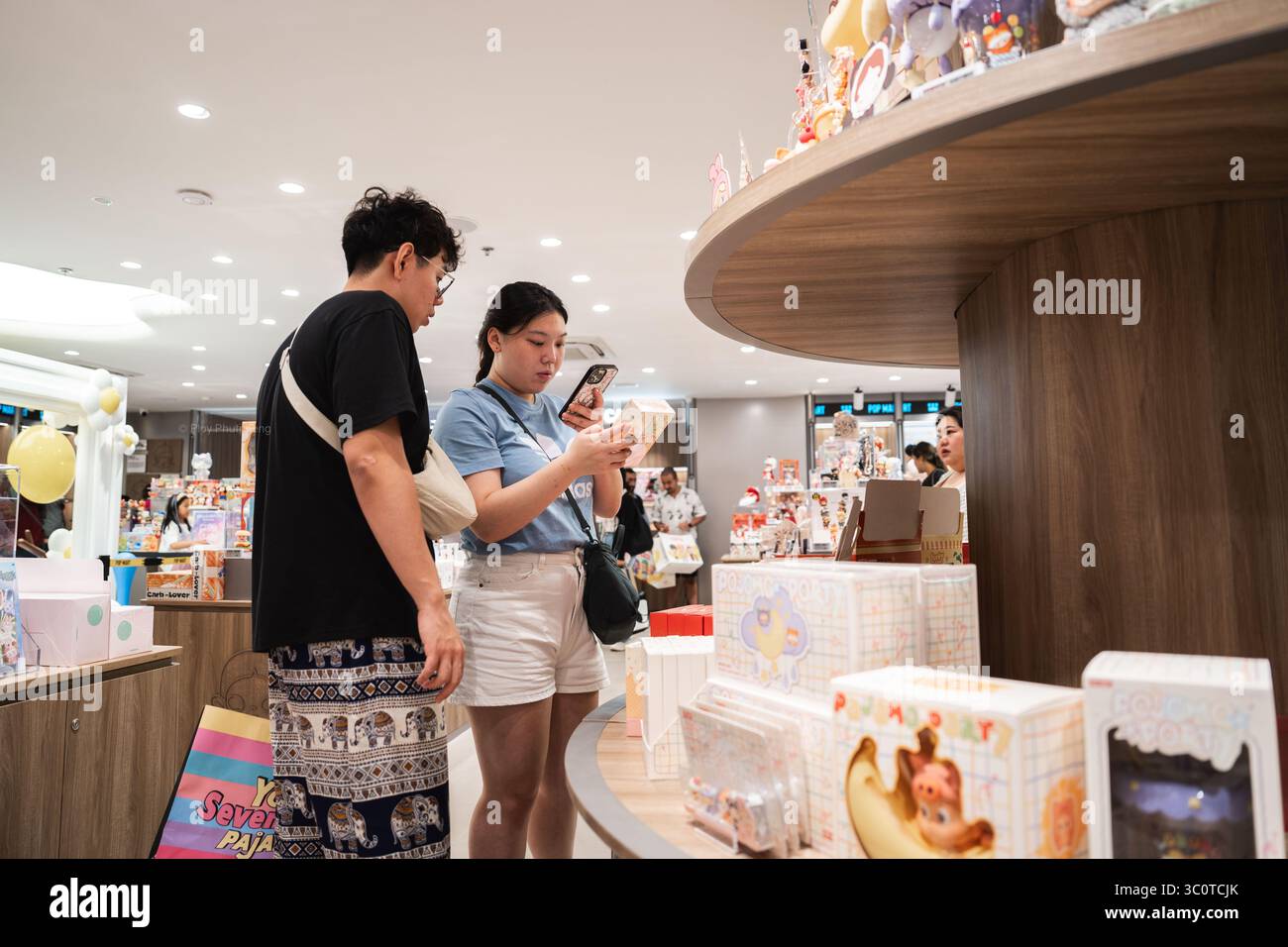 A couple inspects a new blind box release at a Pop Mart store. Pop Mart ...