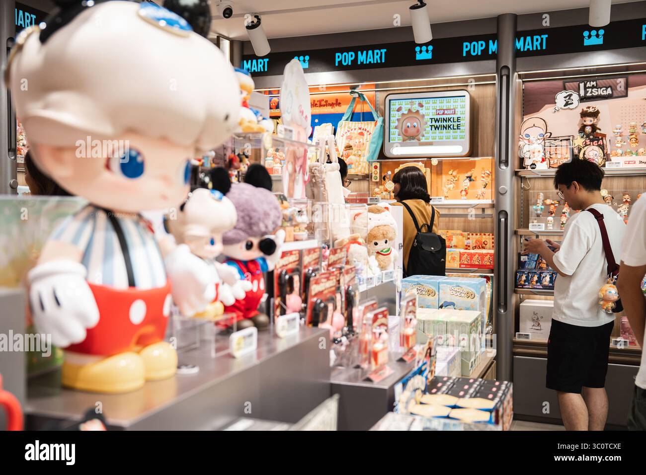 Shoppers browse limited-edition designer toys at Pop Mart store. Pop ...