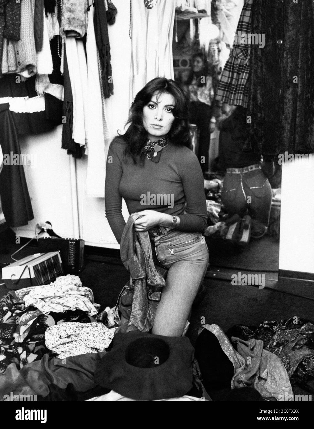 Italian singer Loredana BertÃ© posing kneeling in a clothes shop. Milan ...