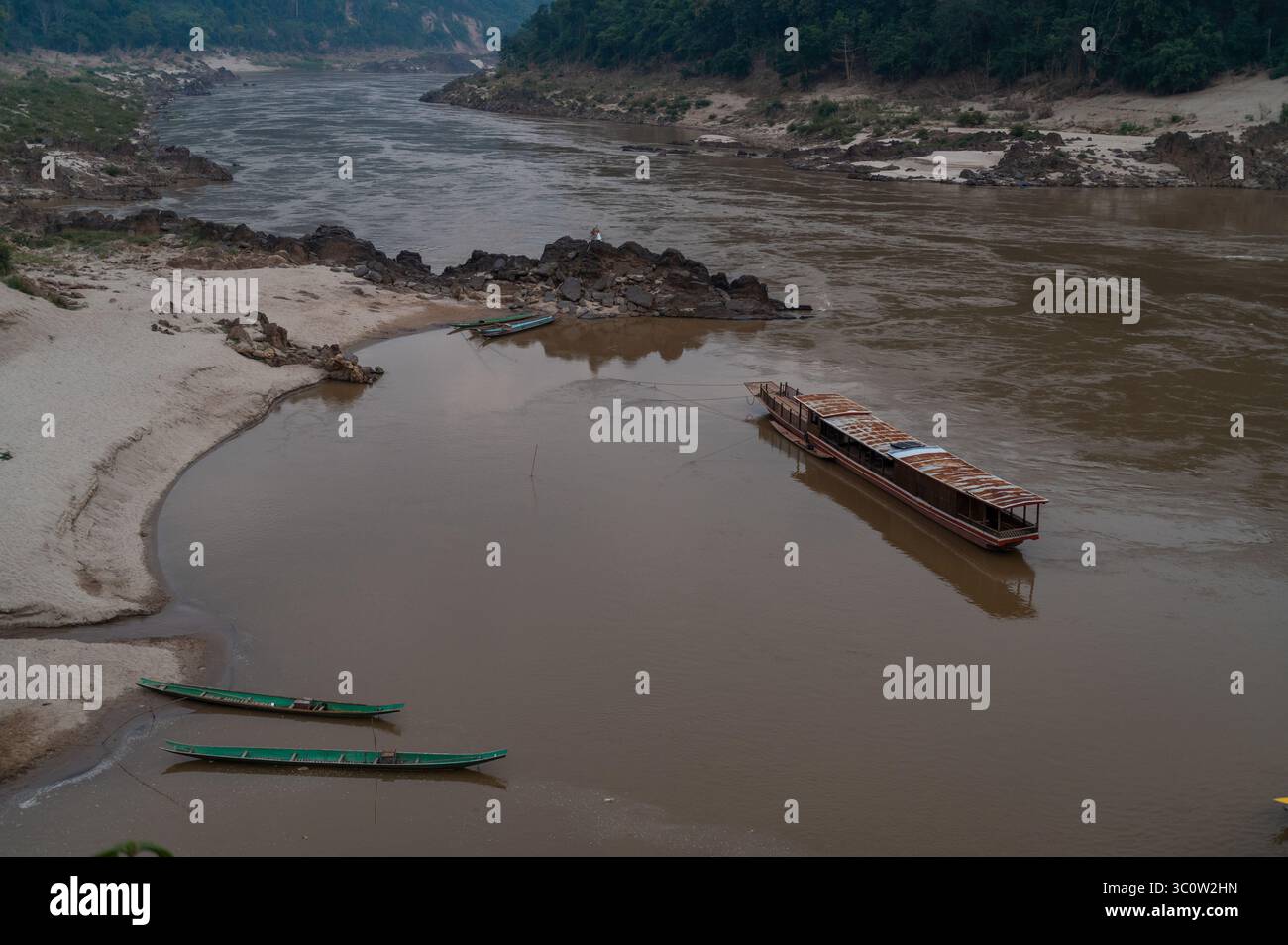 Traditional slow boats glide along the Mekong River showcasing the ...