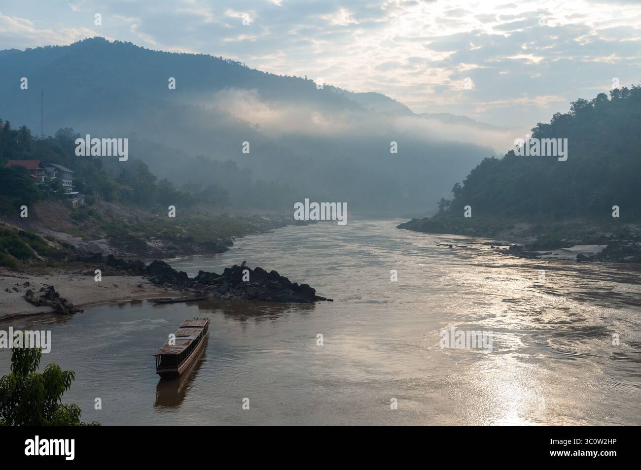 Traditional slow boats glide along the Mekong River showcasing the ...