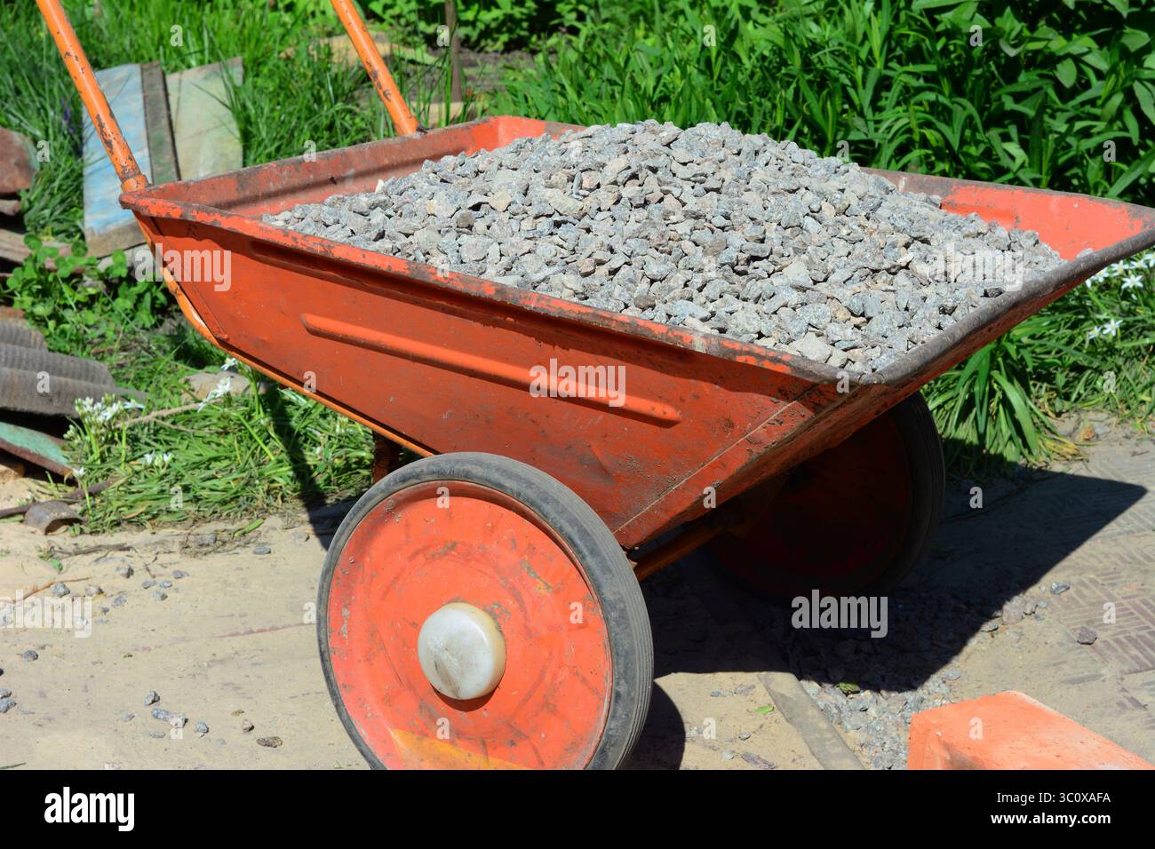 Construction Wheel Barrow with Pile of Gravel for House Foundation ...