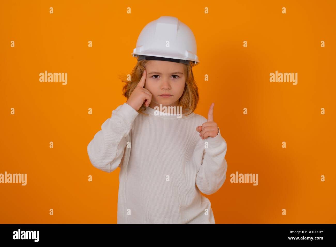Child in builder uniform with hardhat. Happy kid wearing helmet posing ...