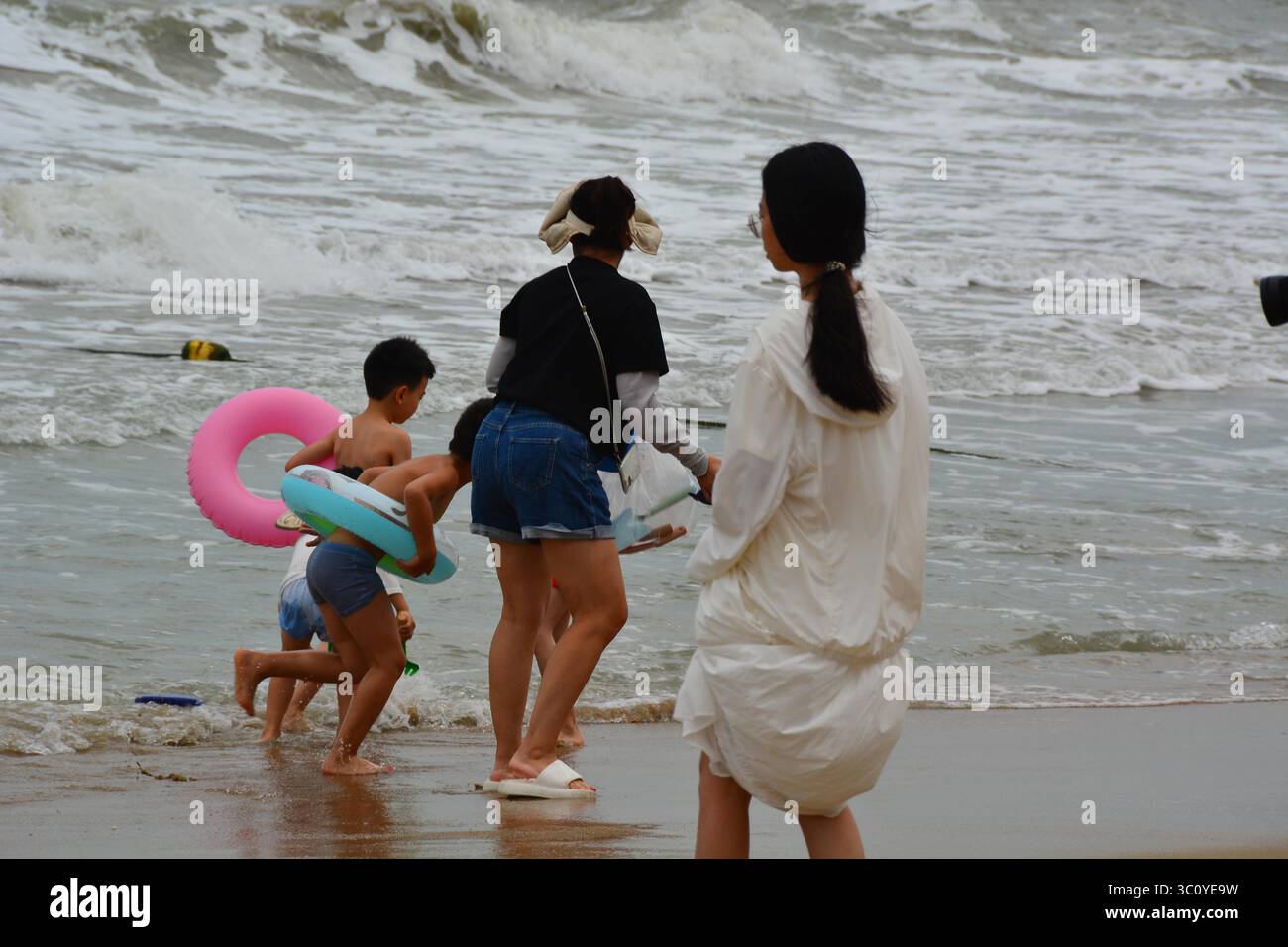 Tourists play at the seaside in Sanya City, southernmost China's Hainan ...