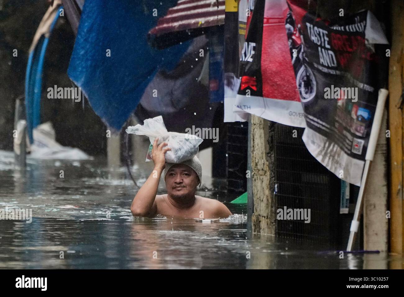 A man wades along chest-deep flood waters following tropical storm ...