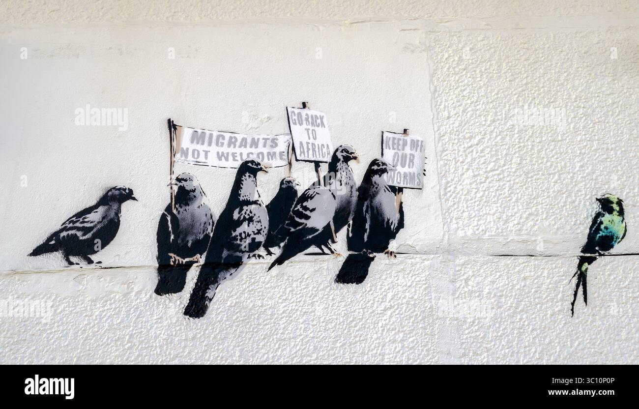 Banksy mural showing a group of pigeons holding anti-immigration ...
