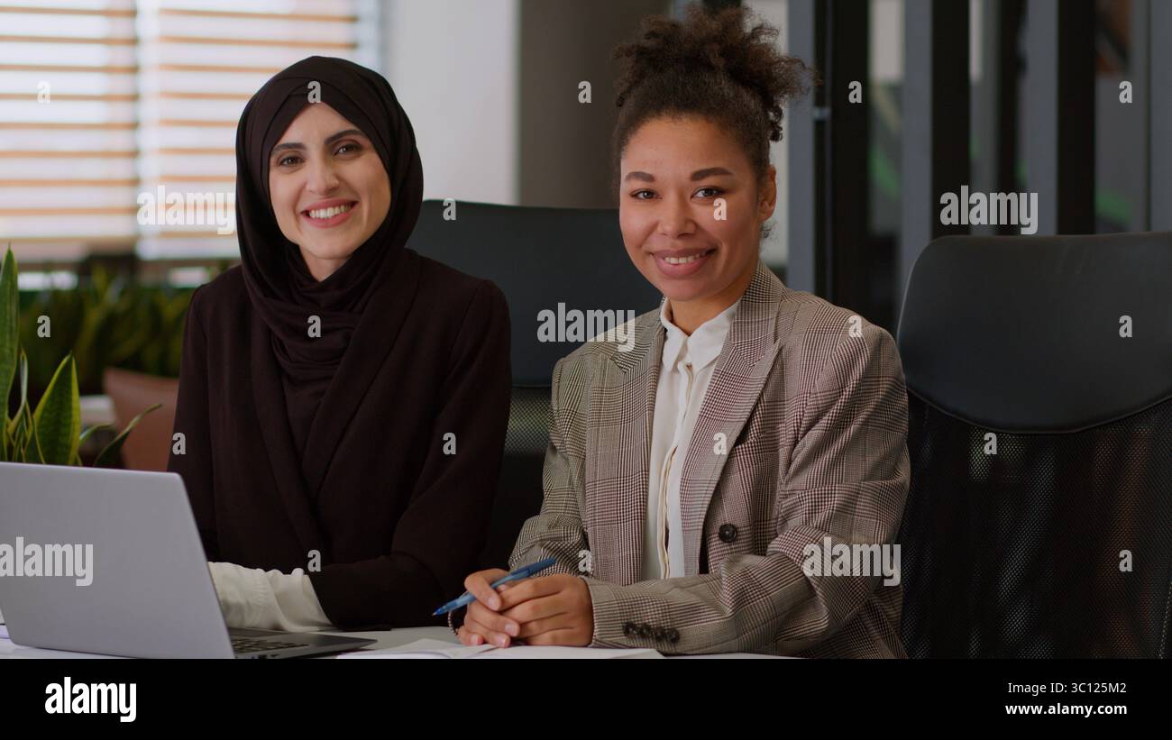 Two multiracial businesswomen female girls ethnic happy colleagues ...