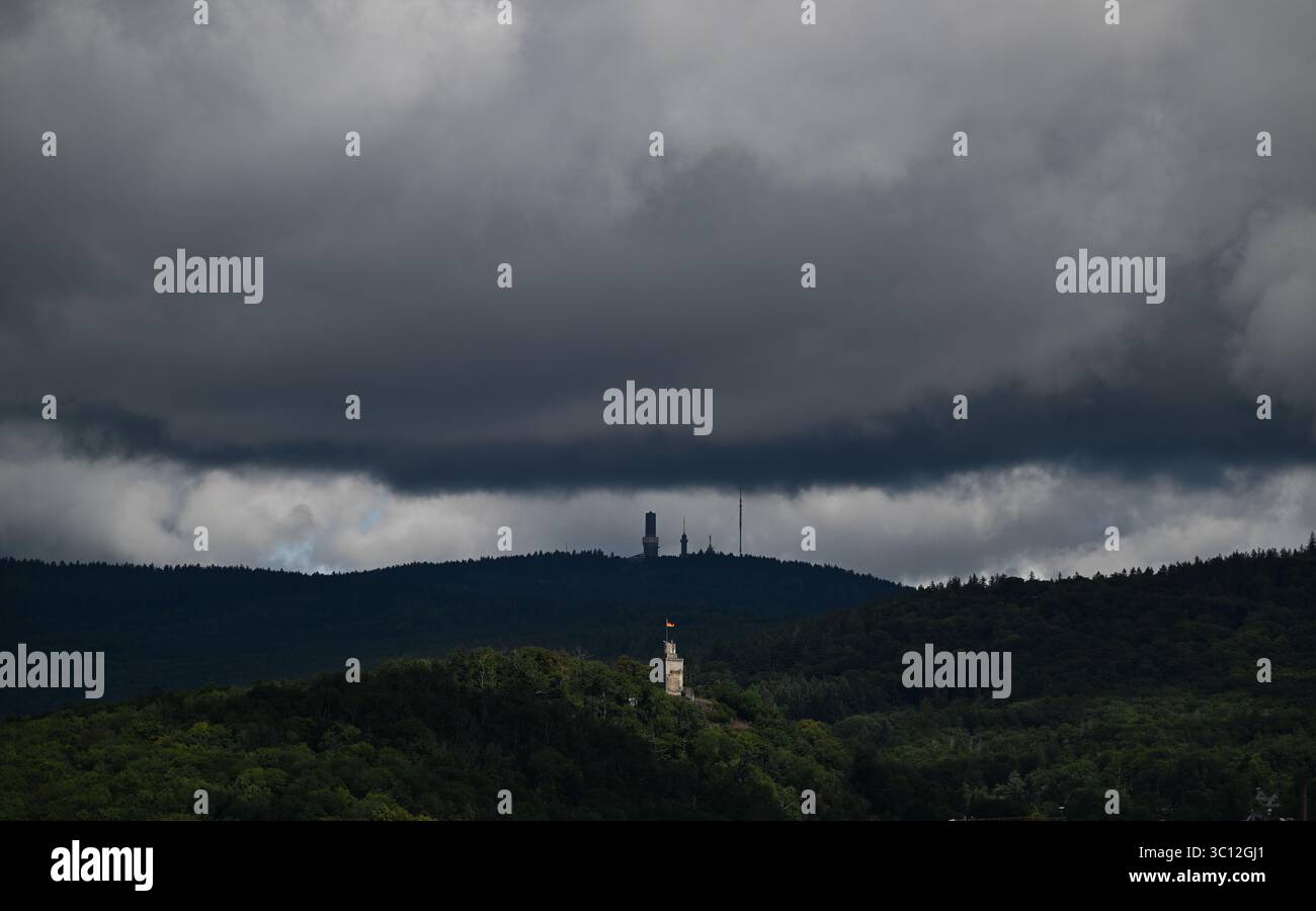 22 July 2025, Hesse, Königstein: Dark clouds drift over the Großer ...