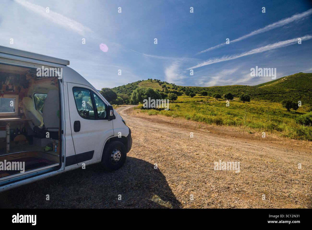 Ein Campingbus steht mit geöffneter Schiebetür neben einer Offroad ...