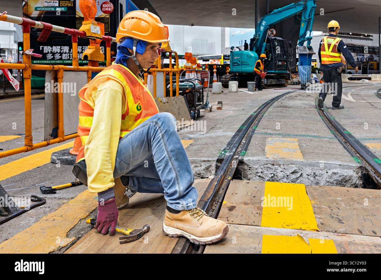 Chinese workers repairing tram line while service is in operation ...