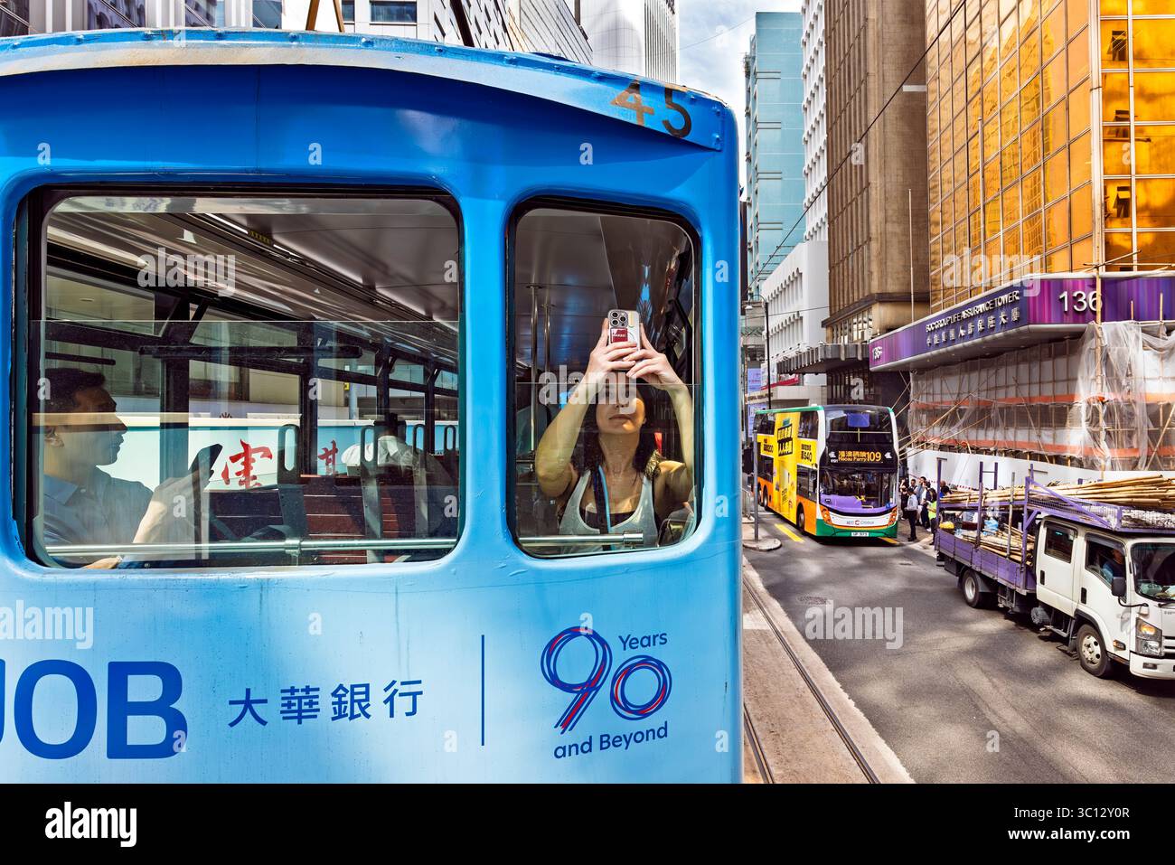 Chinese tourist taking photos from tram window, Causeway Bay, Hong Kong ...