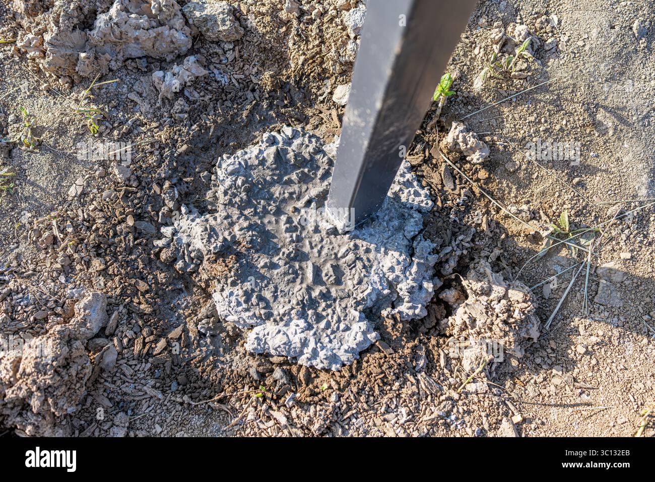 A newly set metal post secured in concrete Stock Photo - Alamy