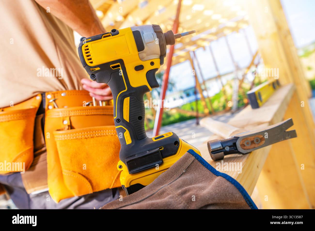 A construction worker operates a power drill at a building site ...