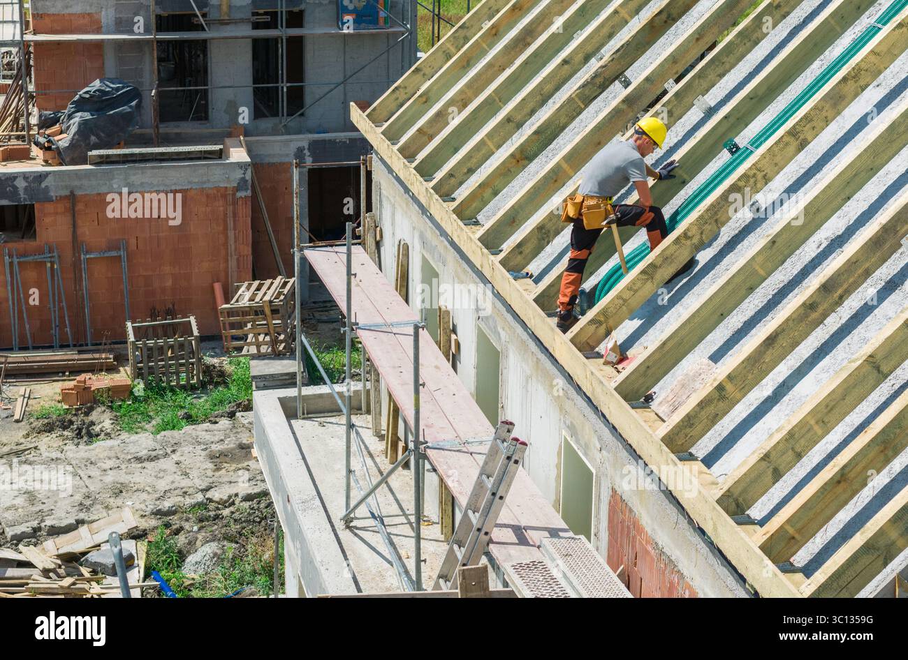 Construction worker carefully places roof hi-res stock photography and ...