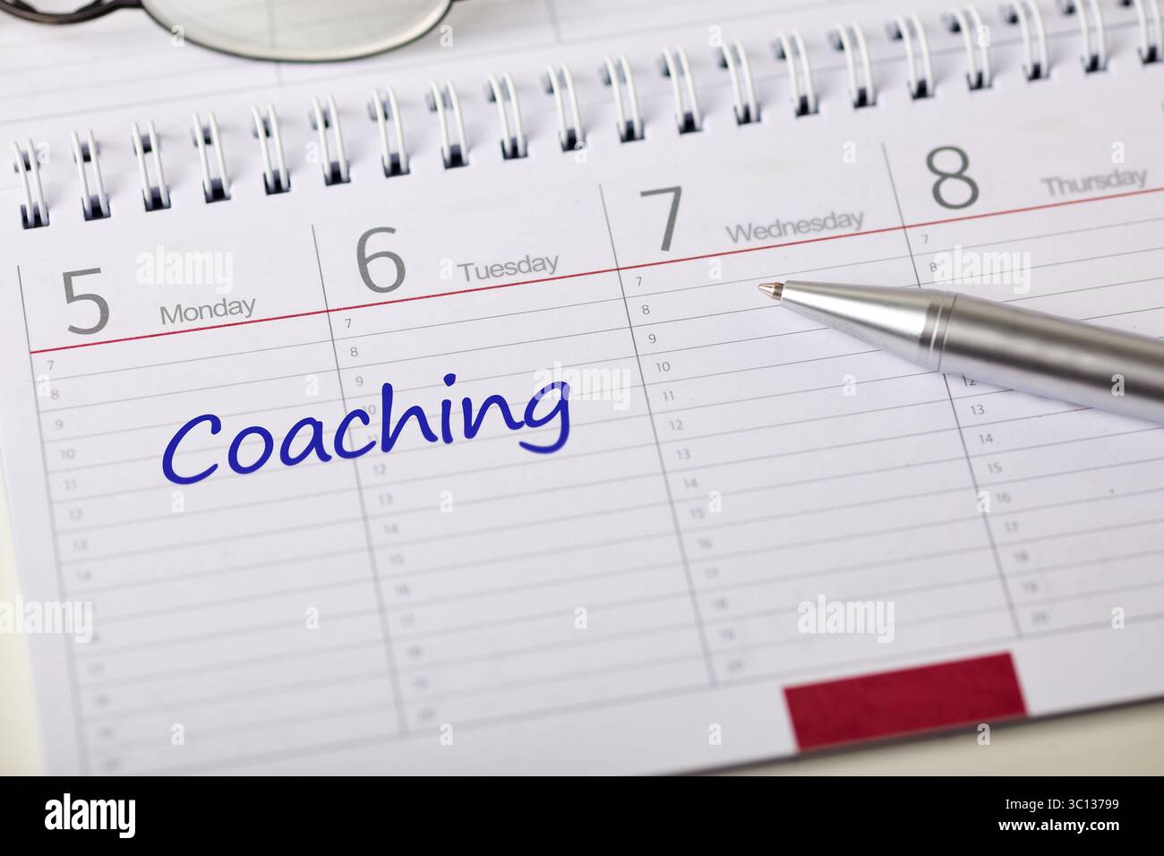 An image of a weekly planner opened with a note for a coaching session ...