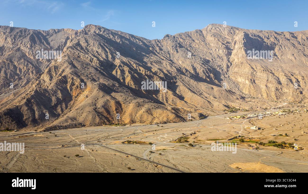 Hajar Mountains and Wadi Ghalilah valley landscape with dry riverbed ...