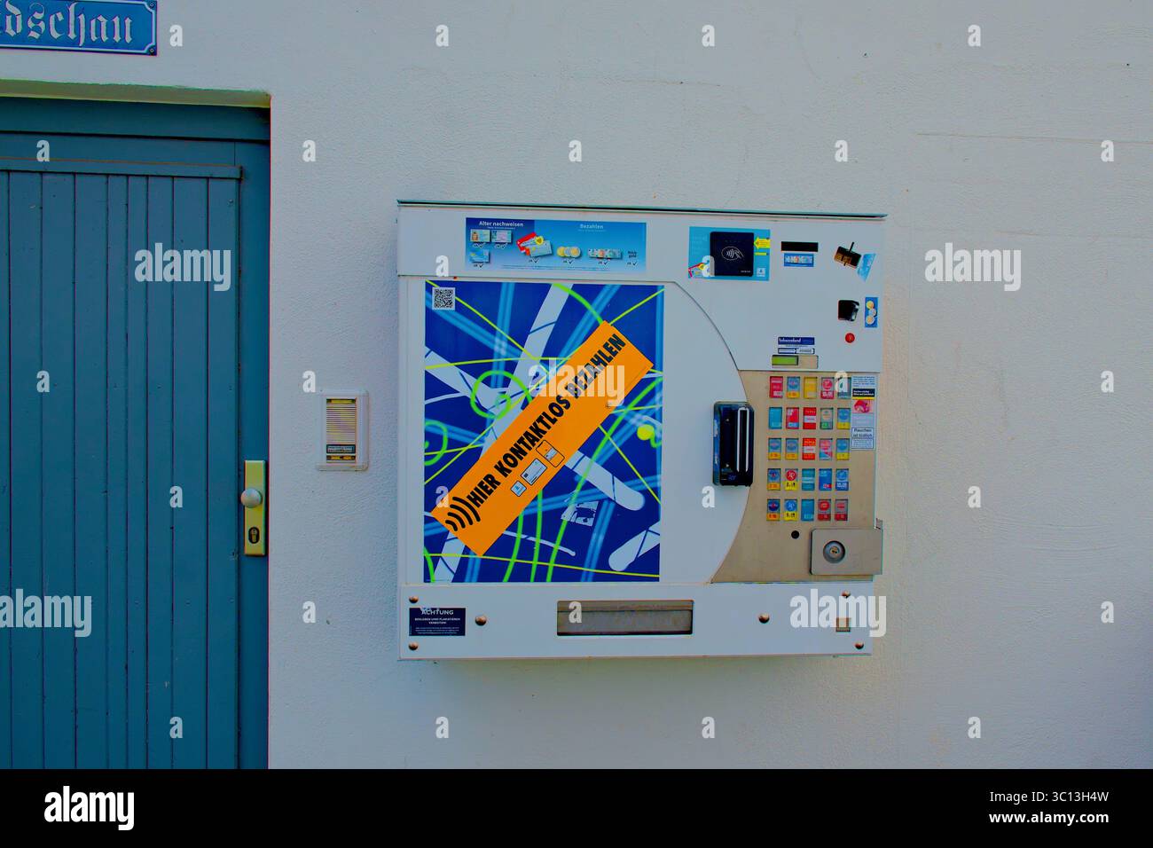 German cigarette vending machine on white wall, outdoor view of street ...