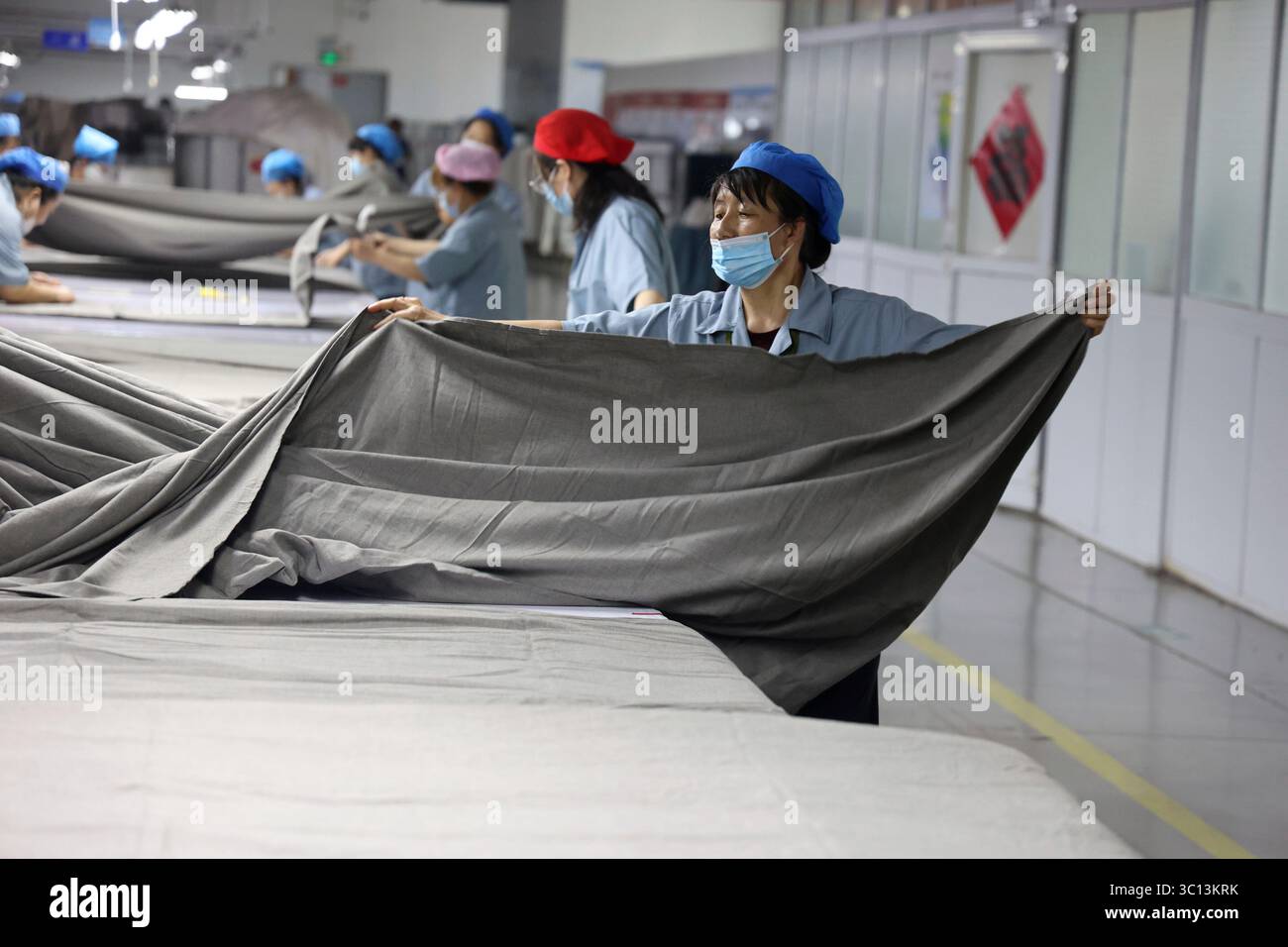 Workers labor at a textile factory of bedding sheets in Binzhou city in ...