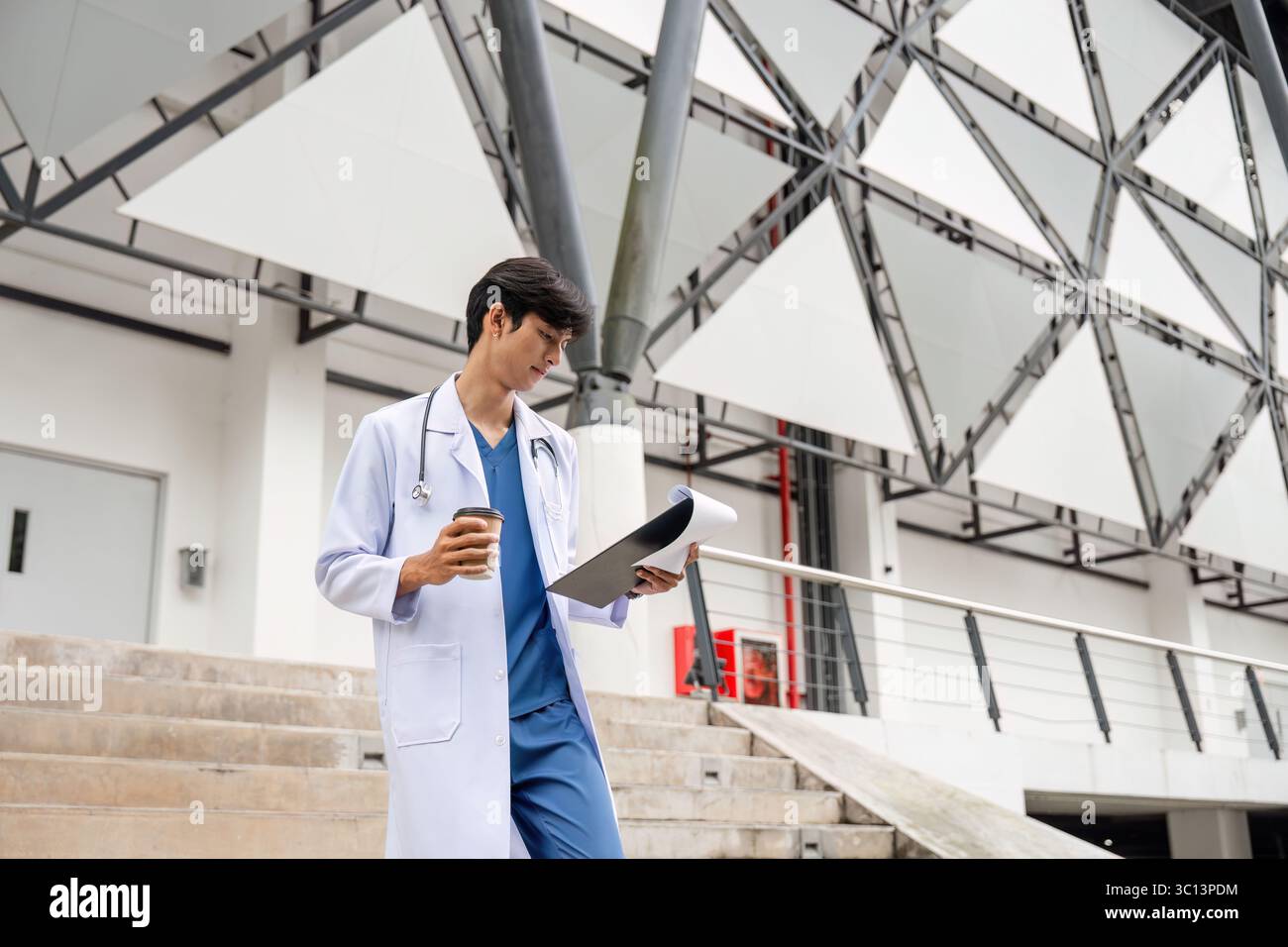 Confident Male Doctor Standing Outside Modern Hospital Building with ...