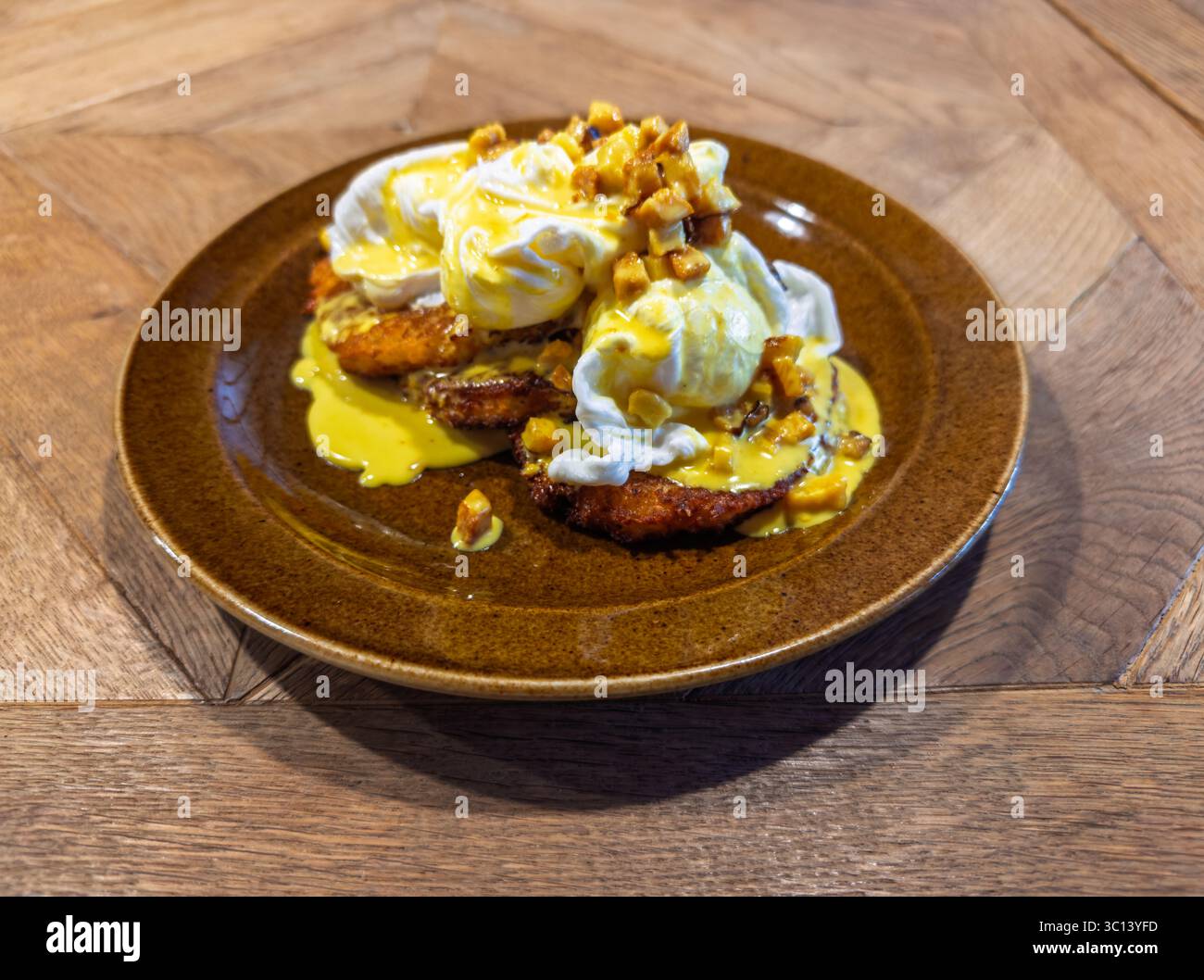 Gourmet breakfast presentation of crisp hash brown cakes layered under ...